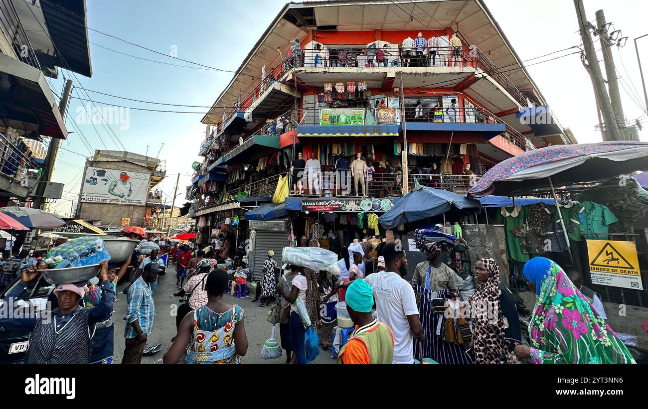 Accra, Ghana. 25th Nov, 2024. Passers-by, customers and traders visit ...