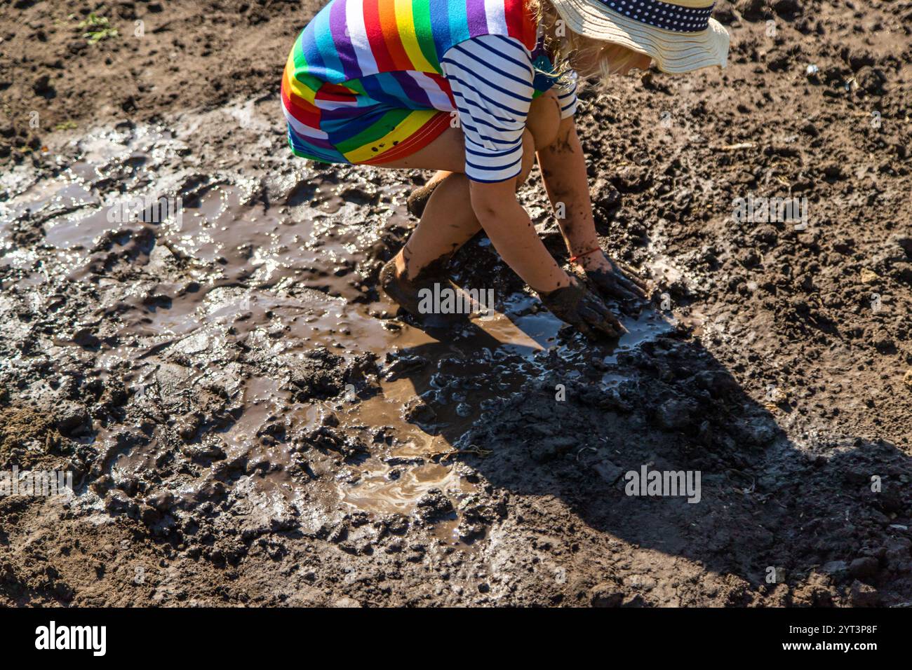 Child playing in mud. Selective focus. Kid Stock Photo - Alamy