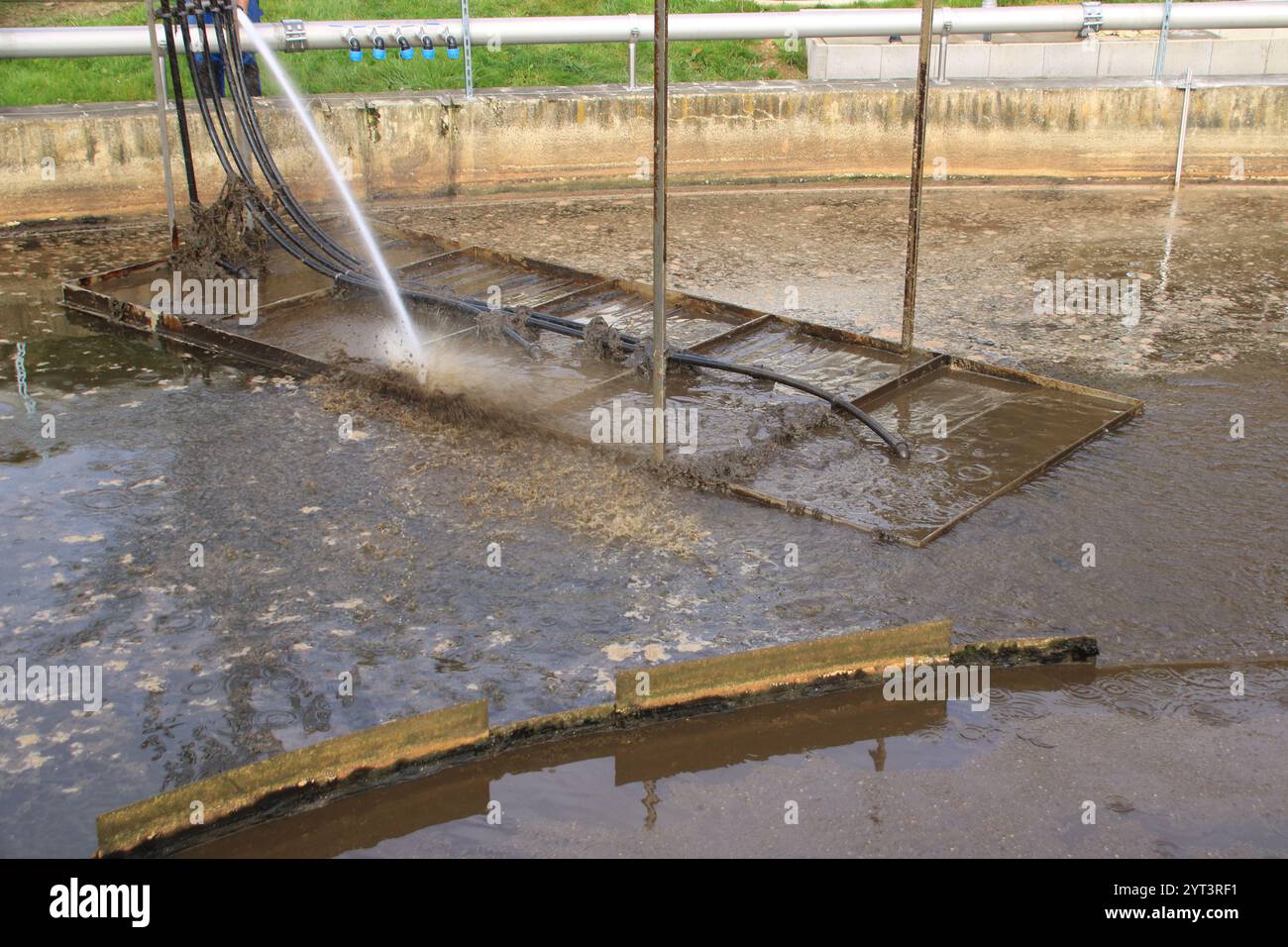 Cleaning an old aerator mat in the aeration tank in a sewage treatment ...