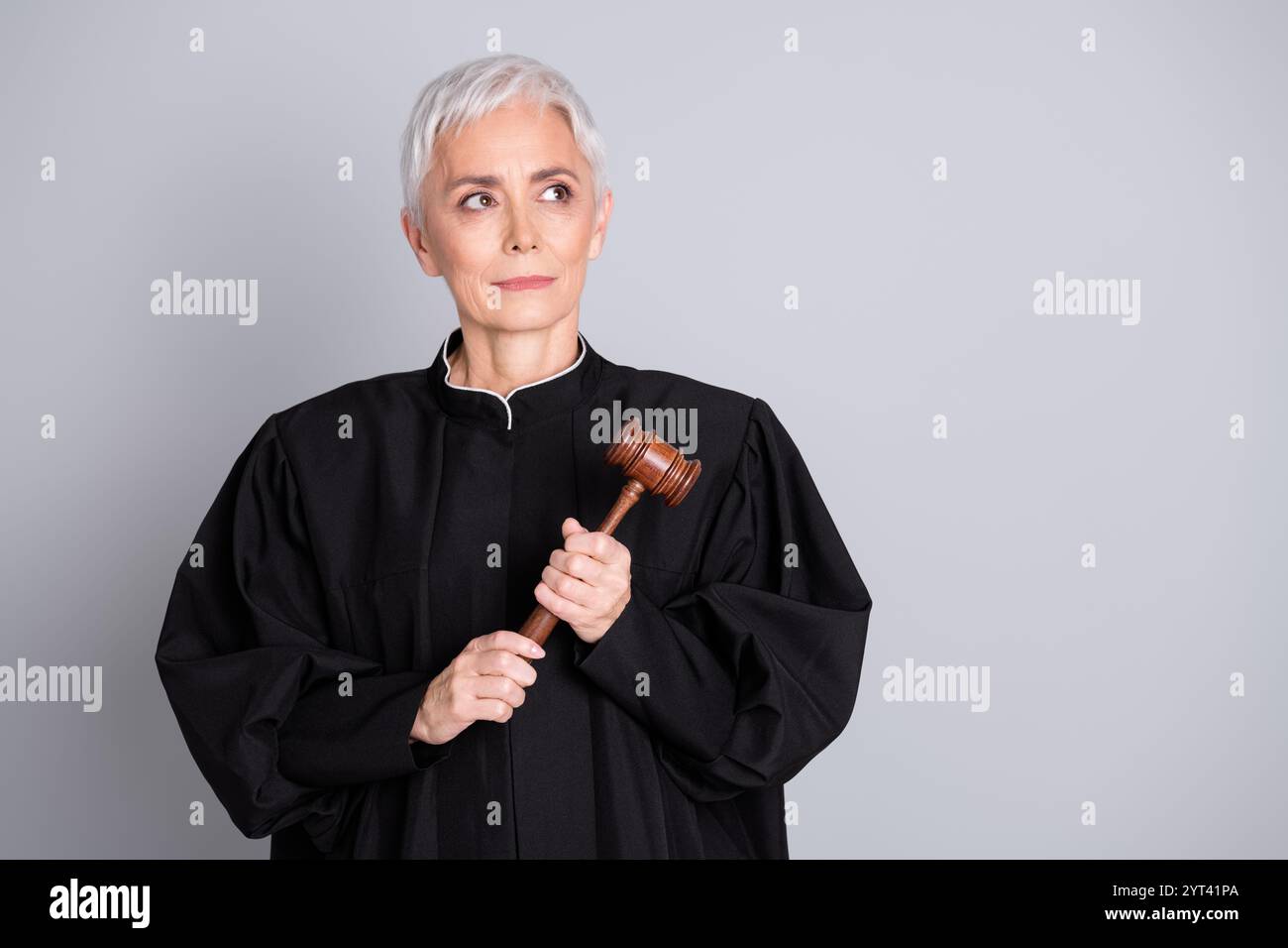 Photo of judge woman hold gavel hammer look empty space wear black robe ...