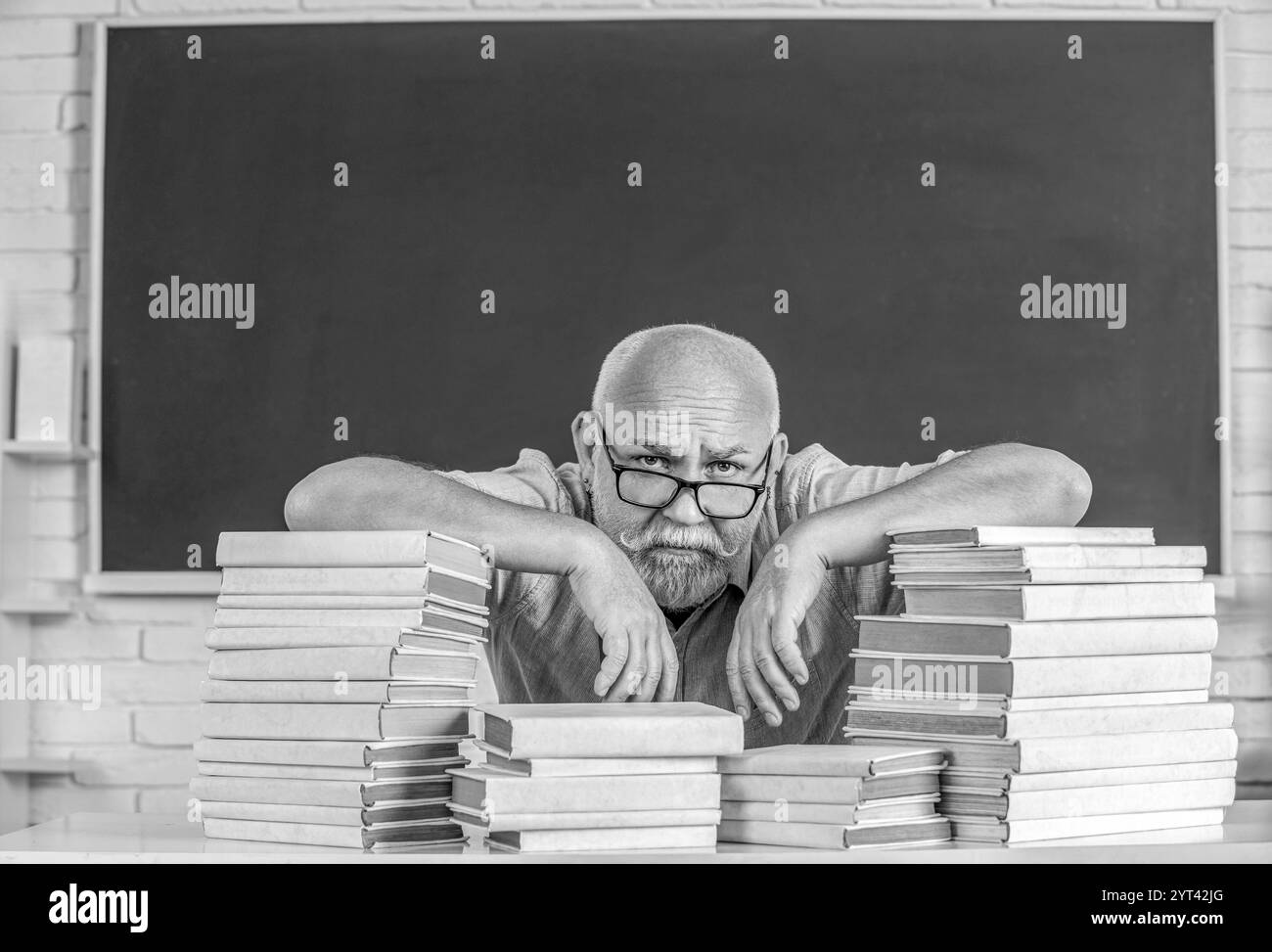 Teacher with books in school. Man school teacher standing in classroom ...