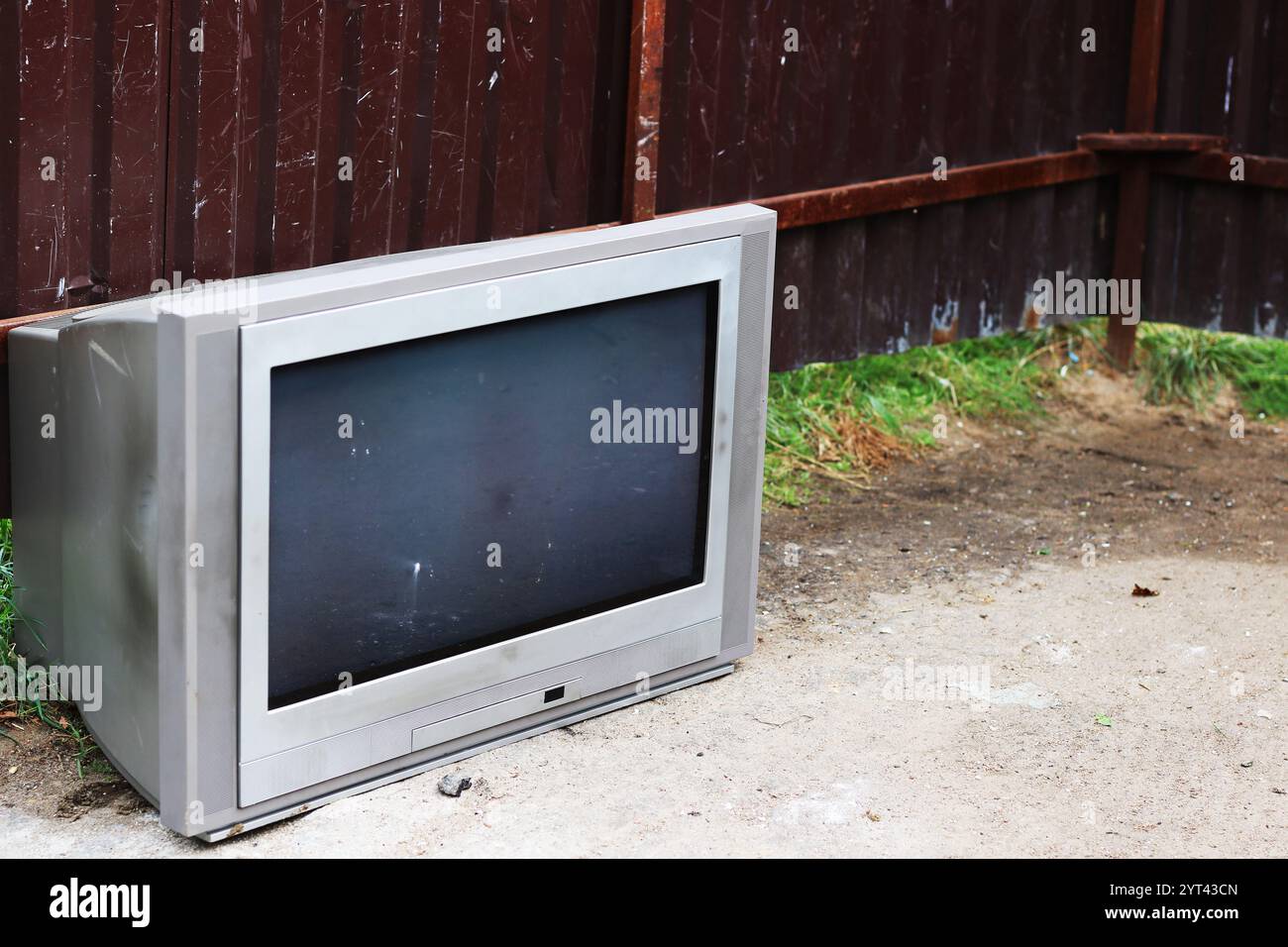 A large television set is positioned on the ground in front of a sturdy ...