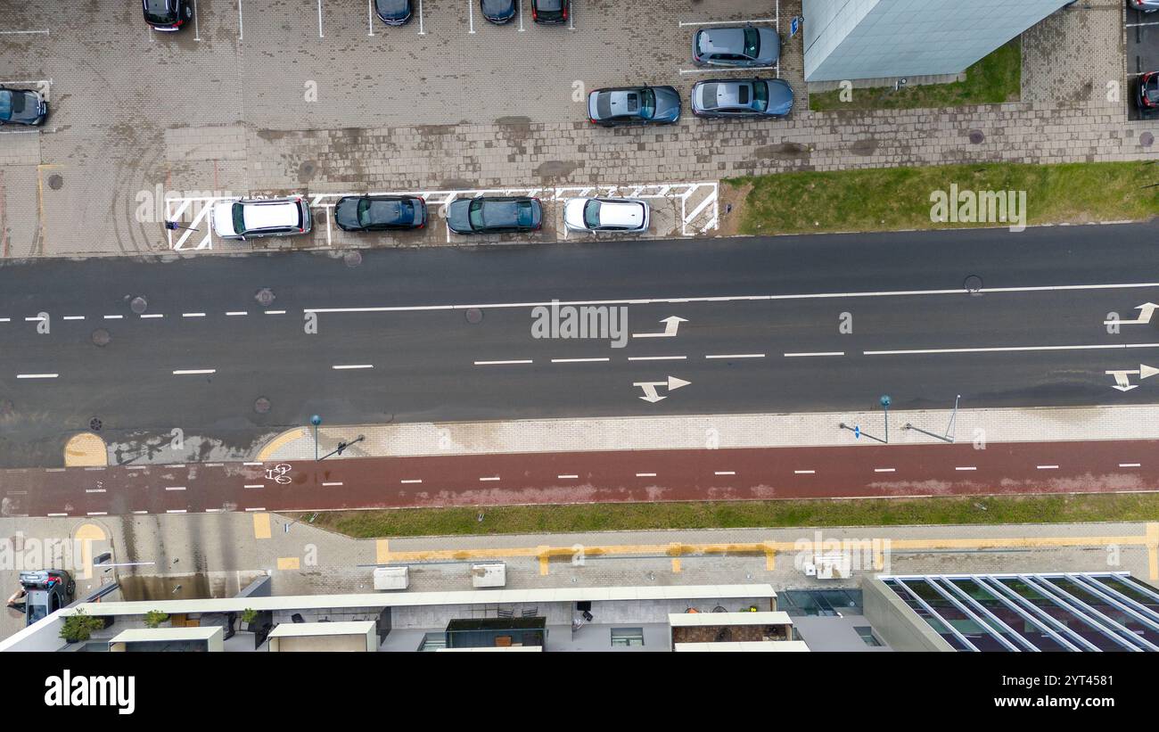 Aerial view of a city street with parked cars, bike lane, and ...