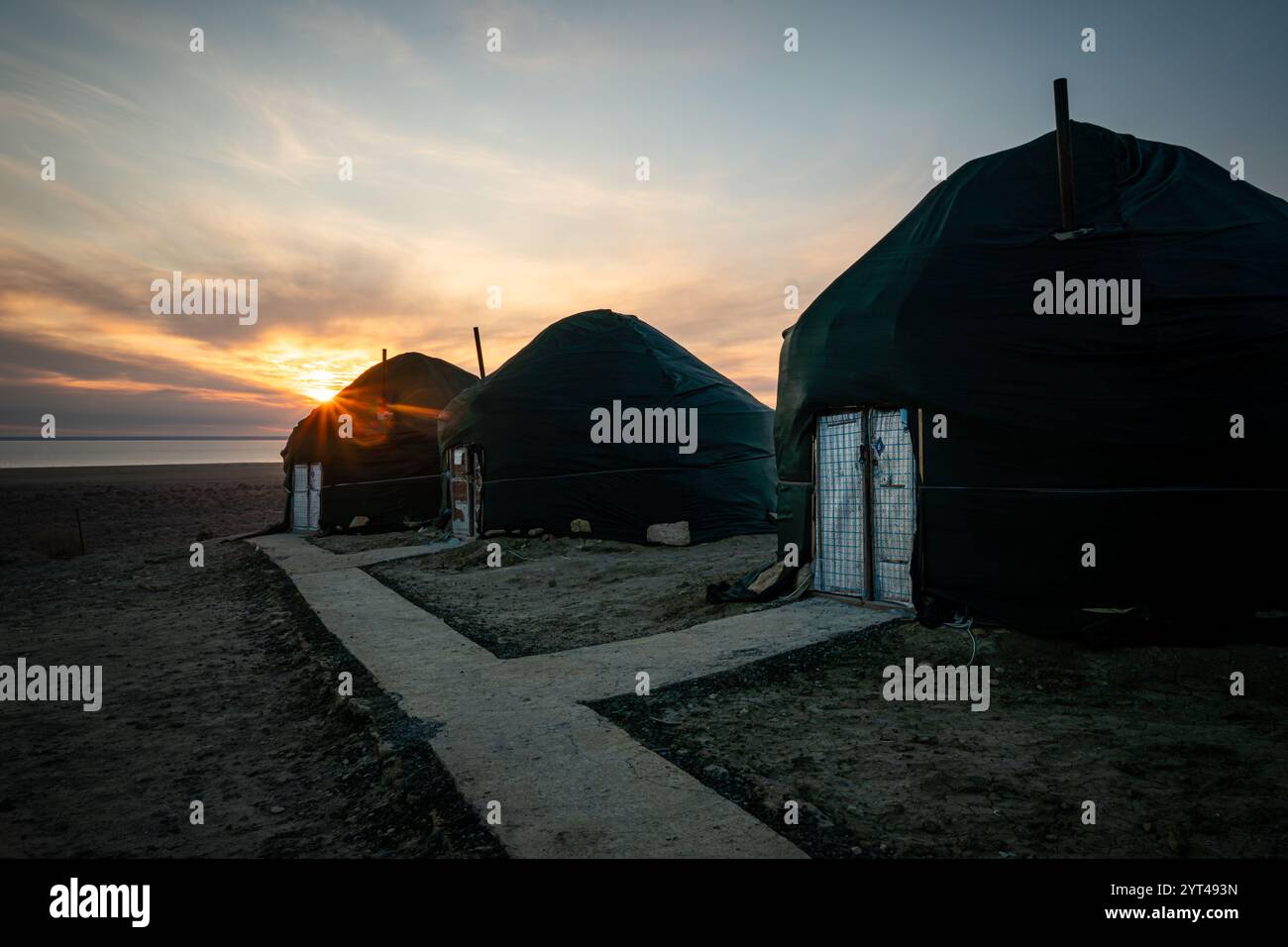 3 is a Yurt in steppe and the oasis at sunset backlit. Blue sky and ...