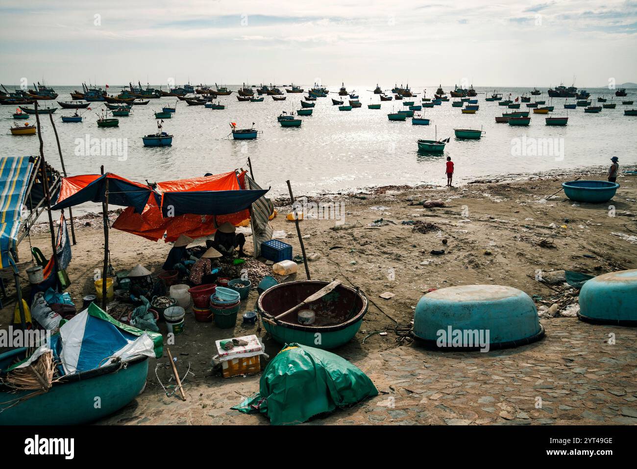 Vietnamese woman throws garbage on the beach by the sea. Dump by the ...