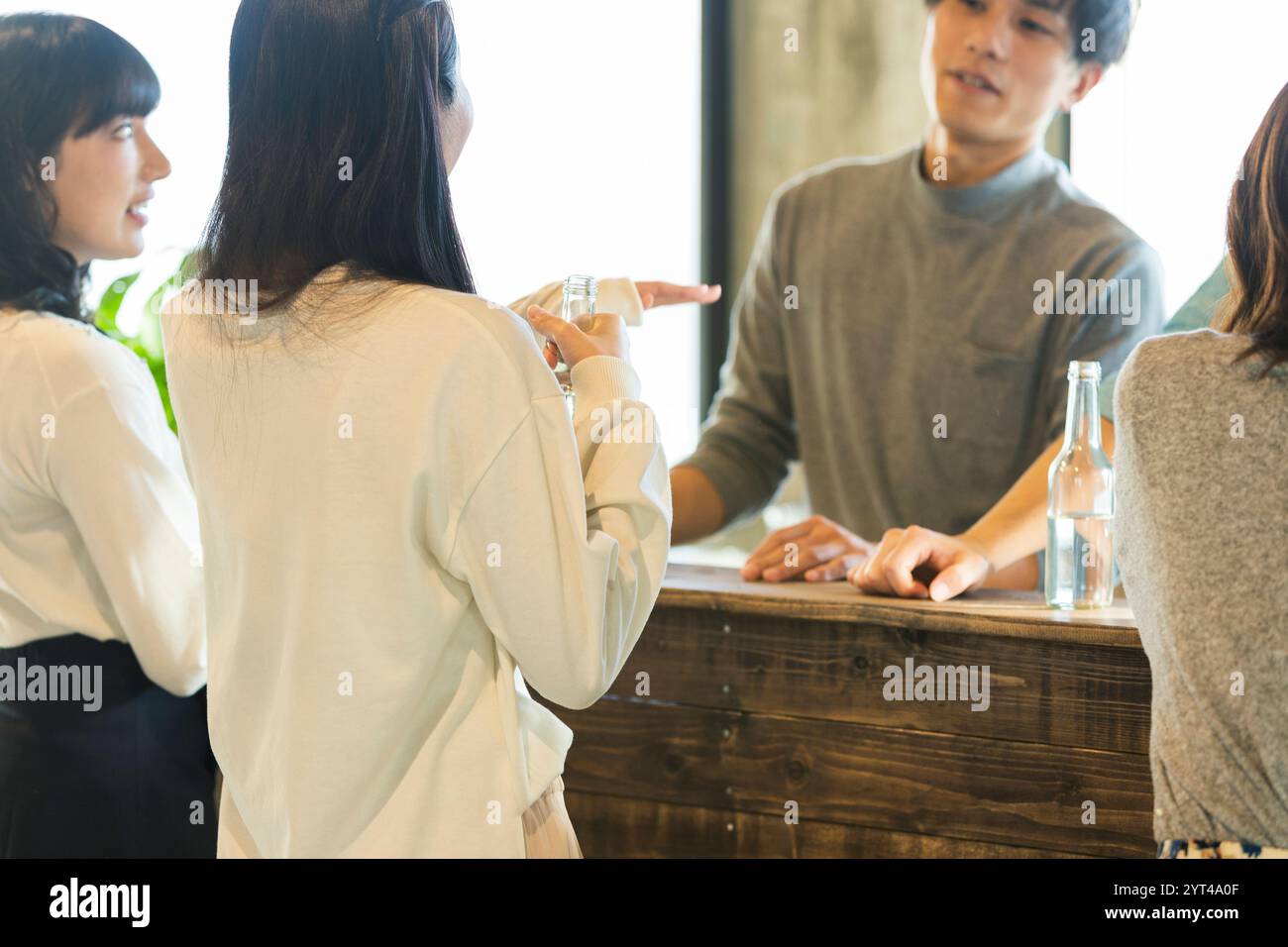 Group of men and women chatting at a bar counter Stock Photo - Alamy