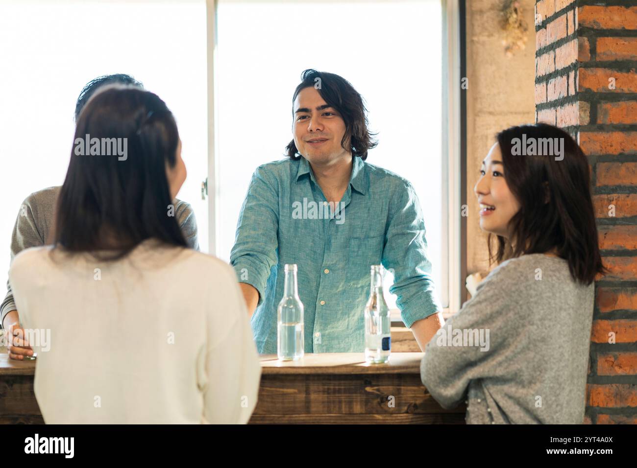 Group of men and women chatting at a bar counter Stock Photo - Alamy