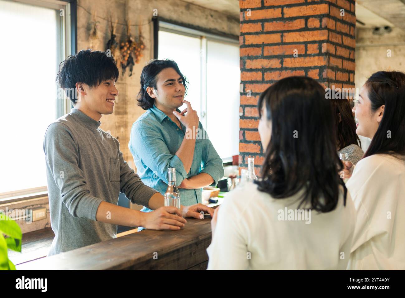 Group of men and women chatting at a bar counter Stock Photo - Alamy