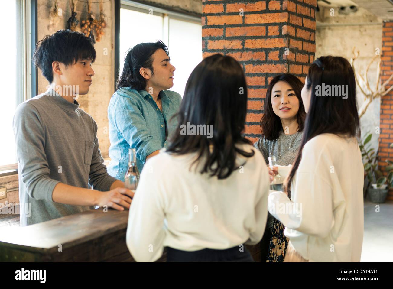 Group of men and women chatting at a bar counter Stock Photo - Alamy