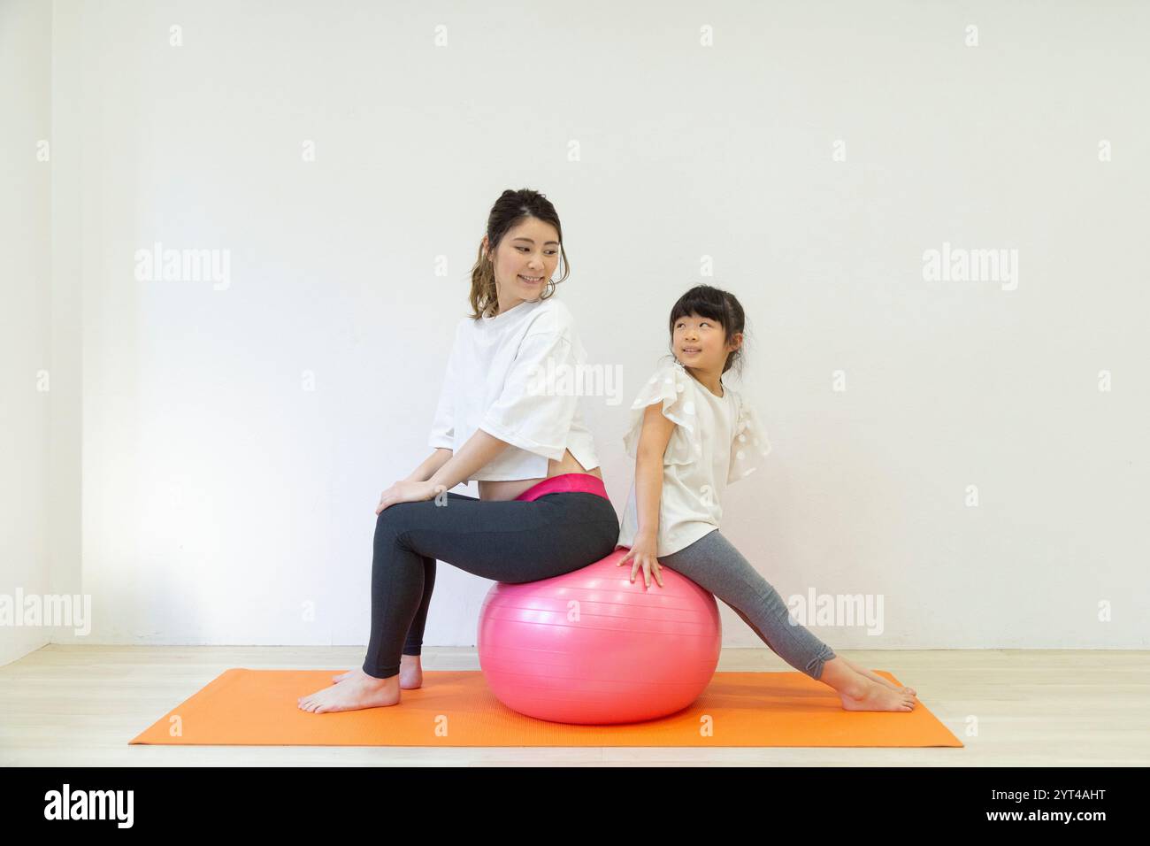 Parent and child sitting on balance ball Stock Photo - Alamy