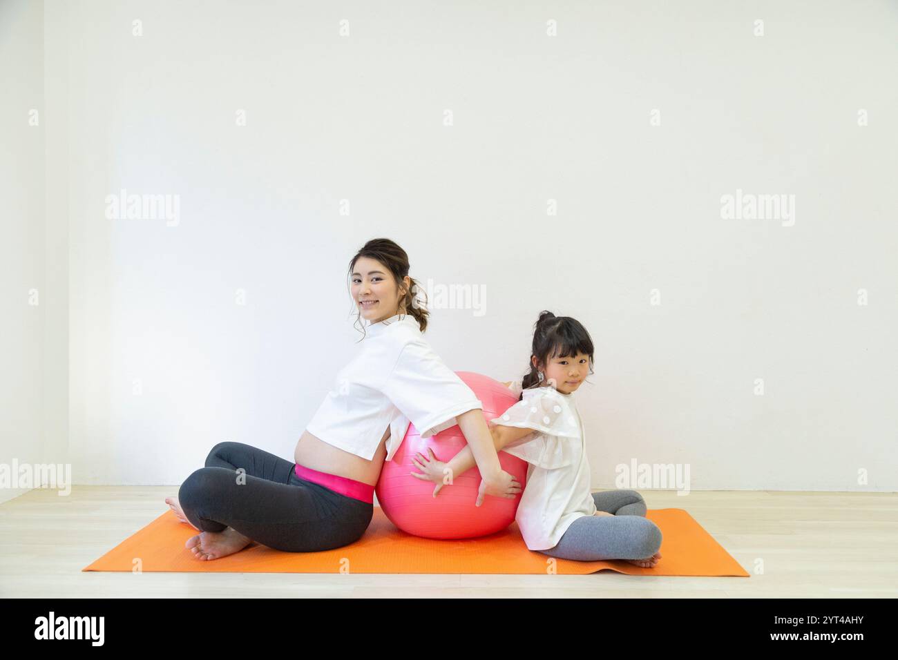 Parent and child holding balance ball Stock Photo - Alamy