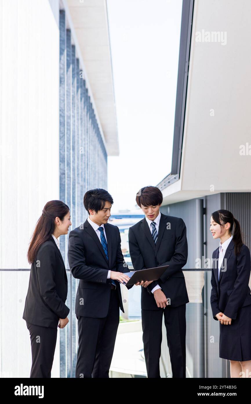 Group of young people looking at a computer Stock Photo - Alamy