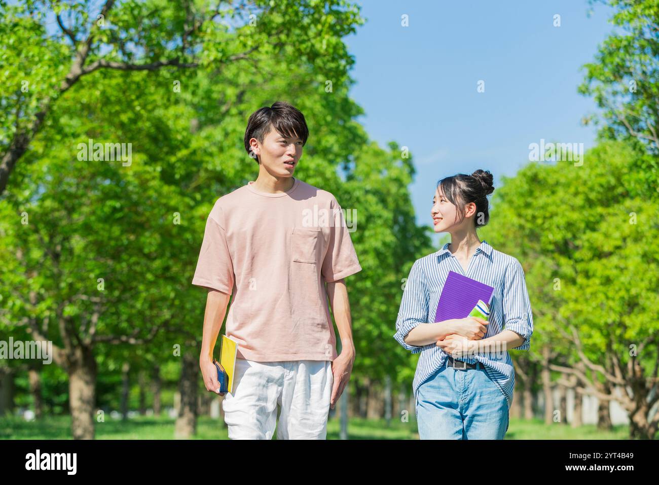 Two young people walking while conversing Stock Photo - Alamy