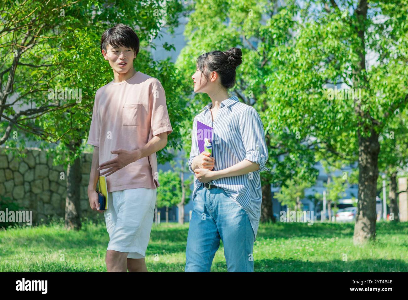 Two young people walking while conversing Stock Photo - Alamy