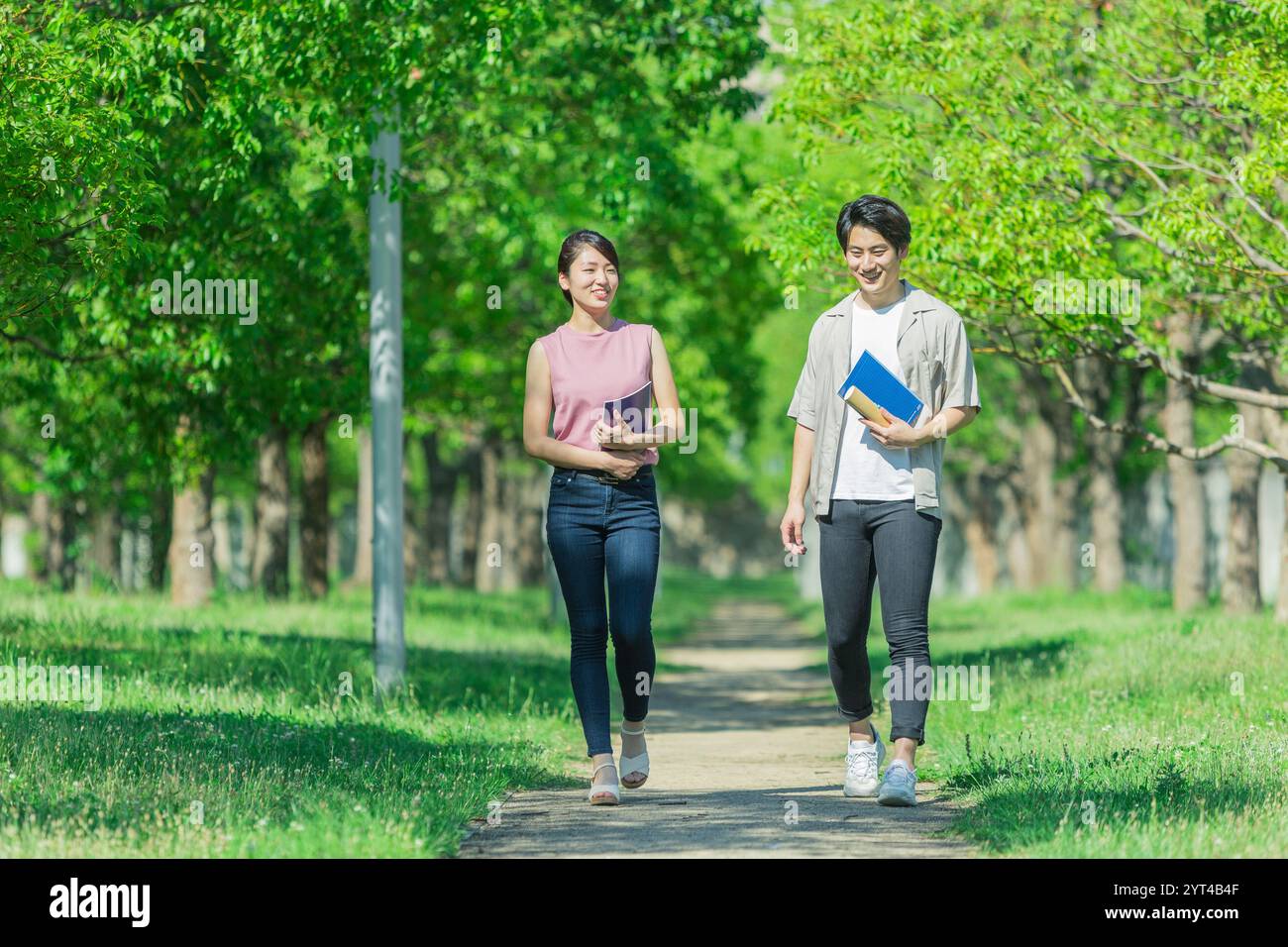 Two young people walking while conversing Stock Photo - Alamy