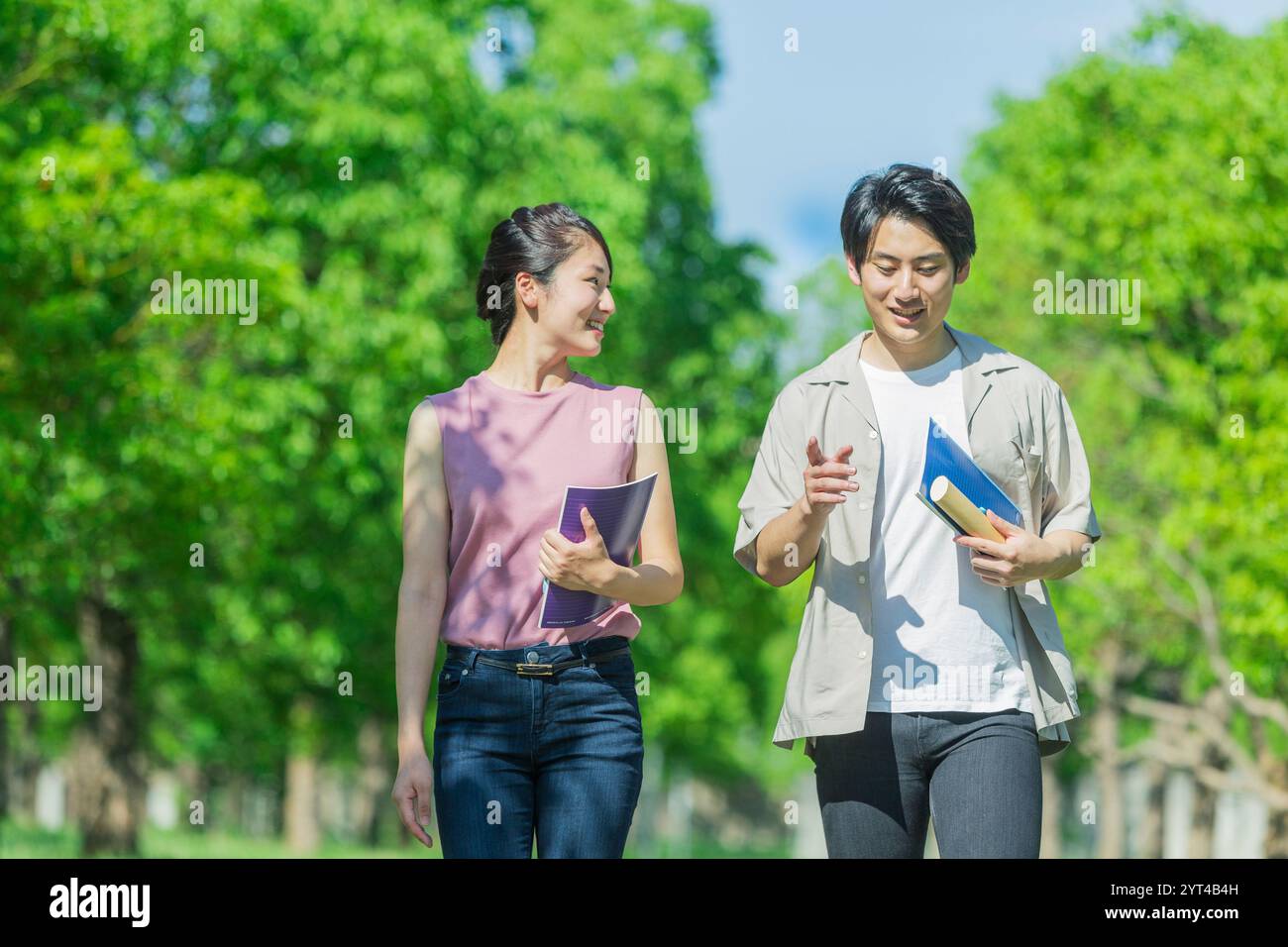 Two young people walking while conversing Stock Photo - Alamy