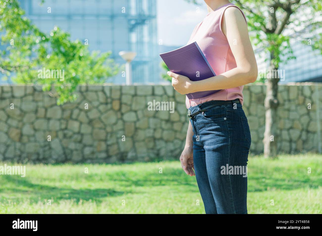 University student standing holding notebook Stock Photo - Alamy