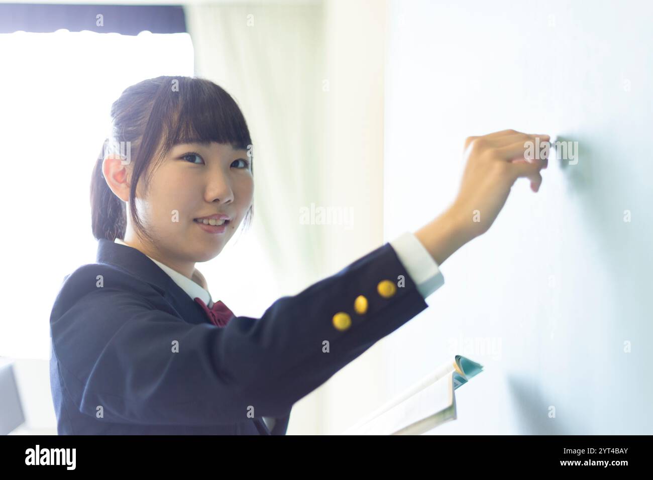 Female high school student writing on blackboard Stock Photo - Alamy