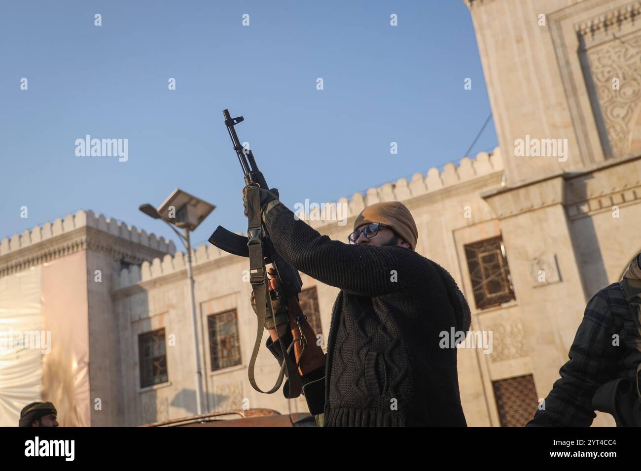 An opposition fighter fires his AK-47 in the air in celebration in Hama, Syria, Friday Dec. 6 ...