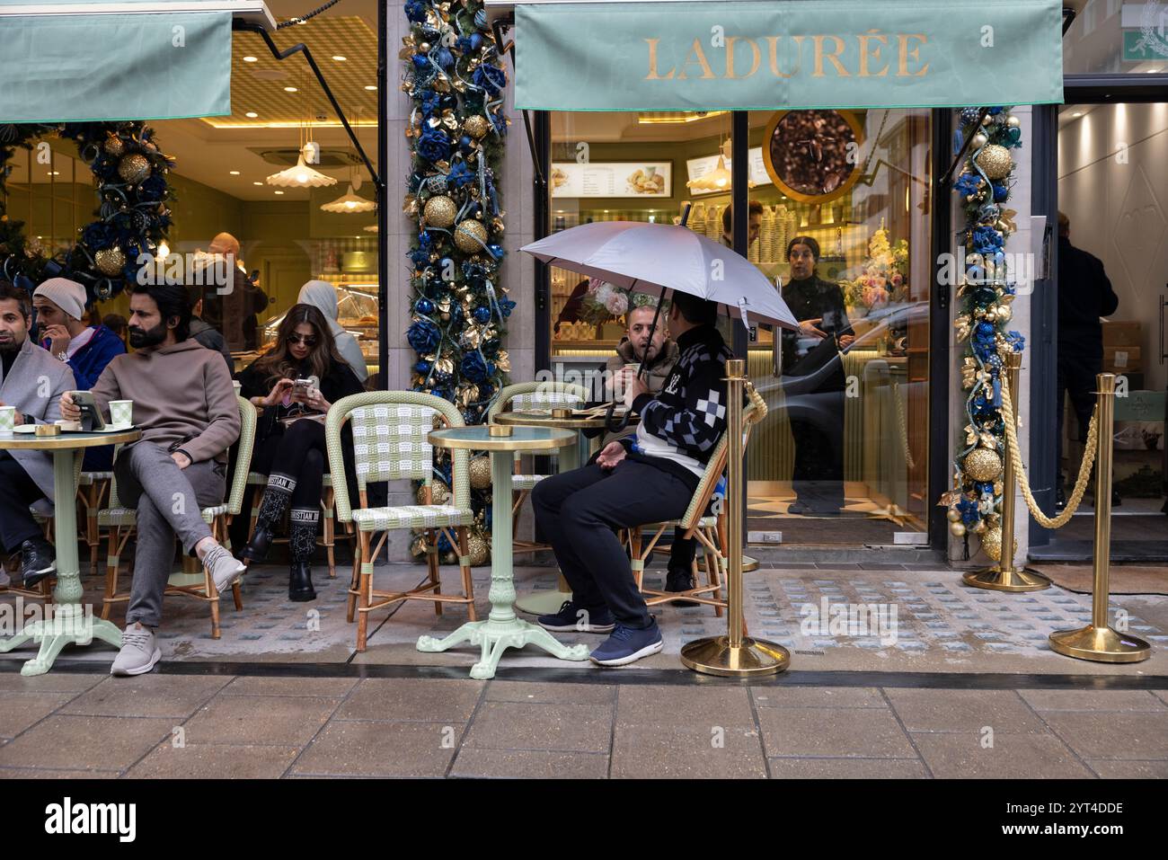 Wealthy arabs sit outside sit outside Ladurée, Parisian luxury bakery ...