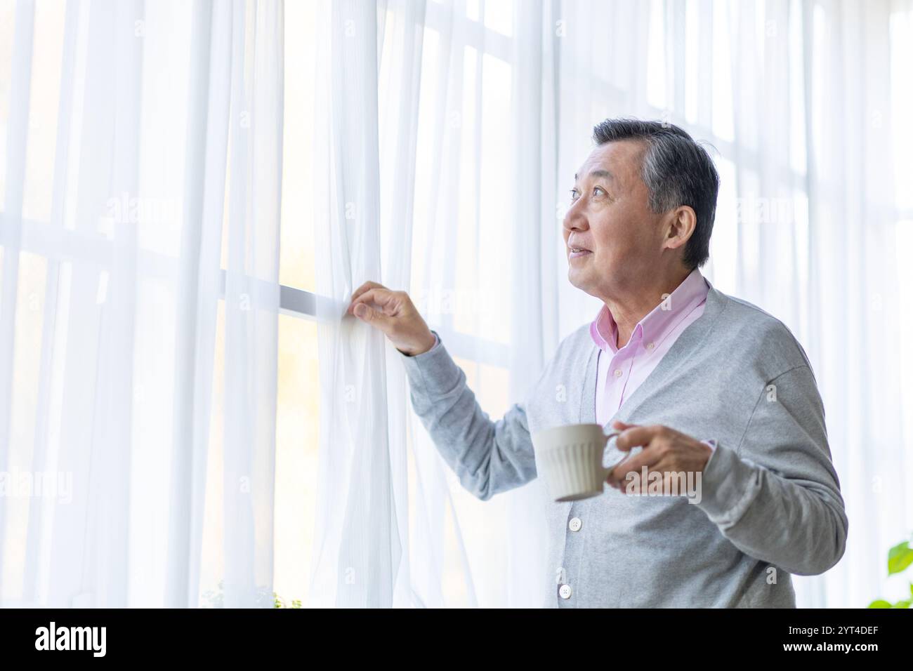 Senior man looking out of window Stock Photo - Alamy