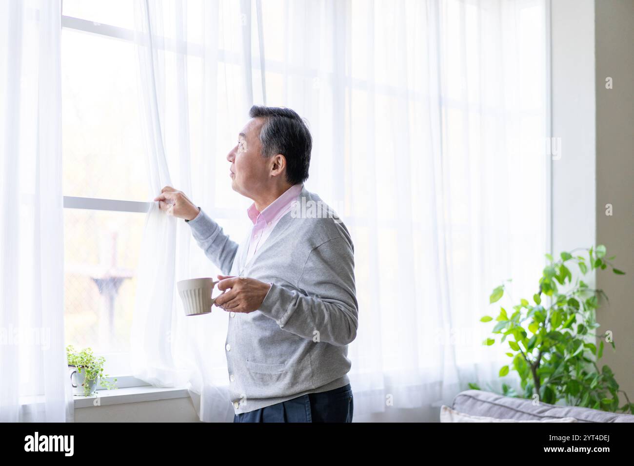 Senior man looking out of window Stock Photo - Alamy