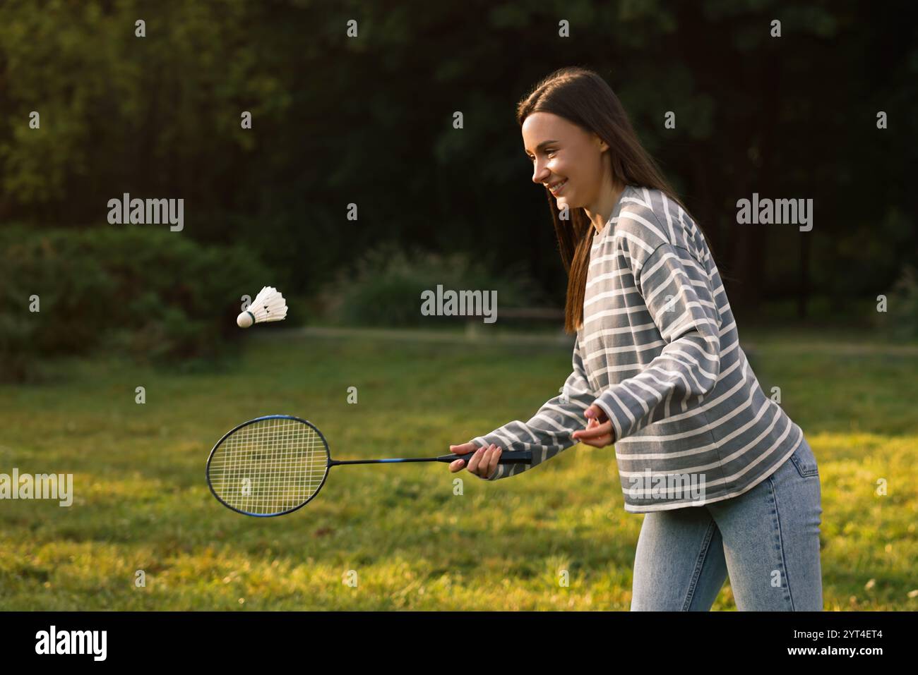 Young woman playing badminton racket in park Stock Photo - Alamy