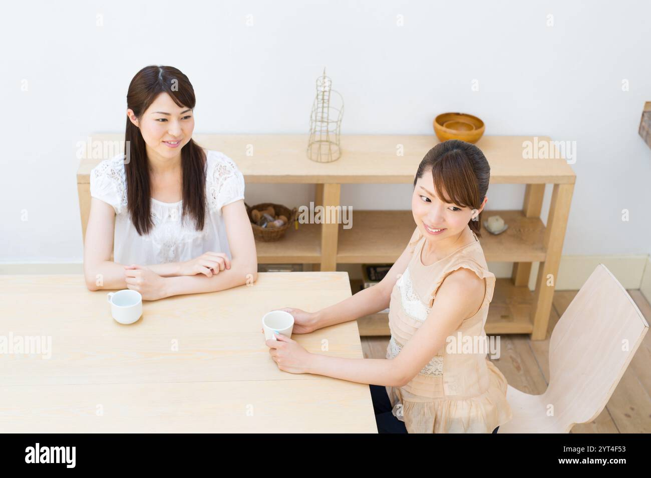 Table two women sit hi-res stock photography and images - Alamy