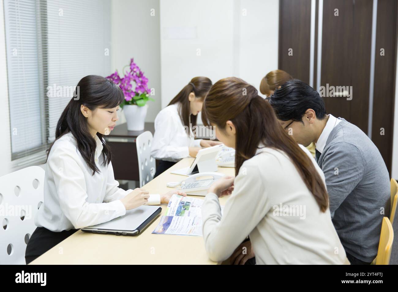 Woman serving customers at counter Stock Photo - Alamy