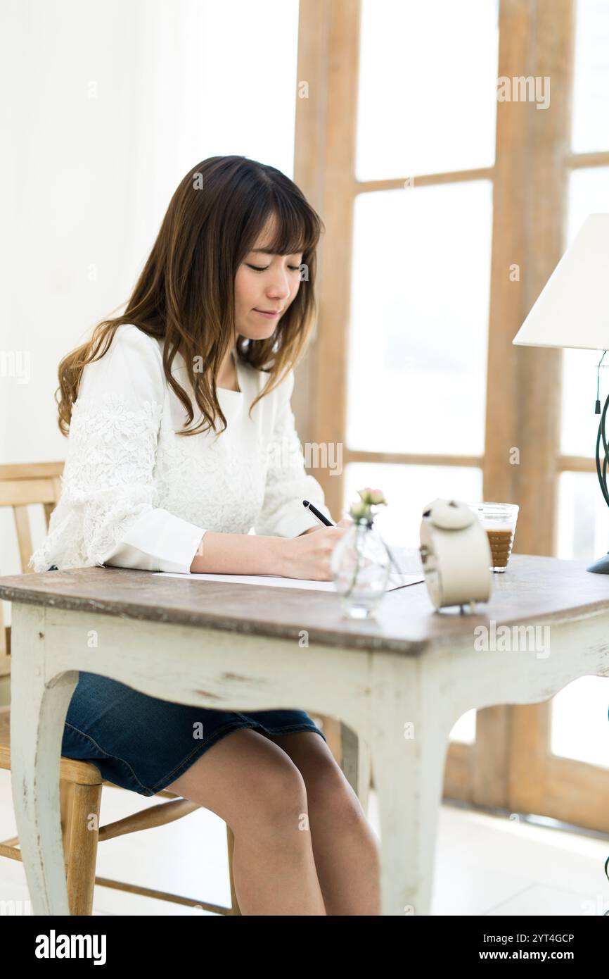 Young woman studying at desk Stock Photo - Alamy