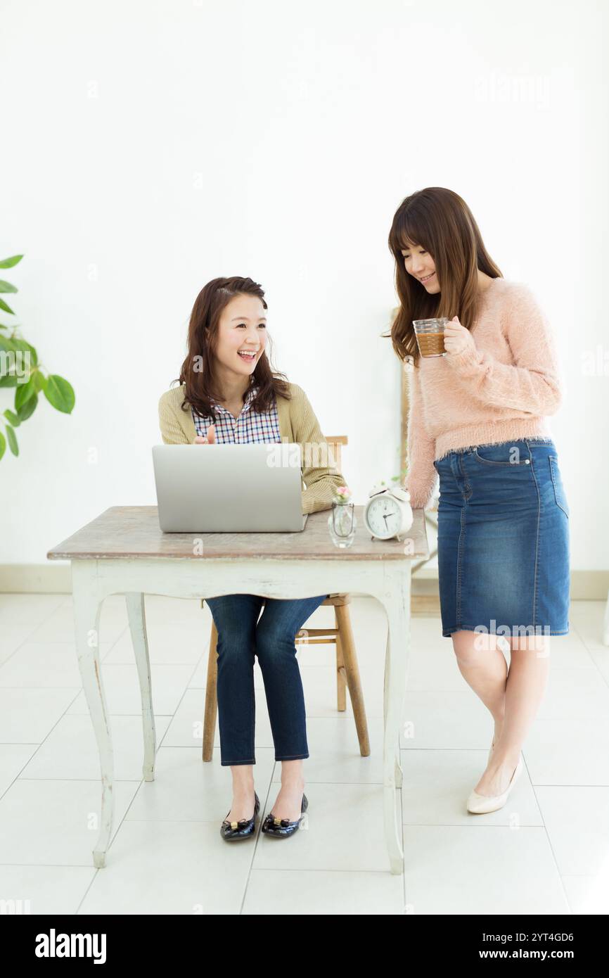 Young women using computer in room Stock Photo - Alamy