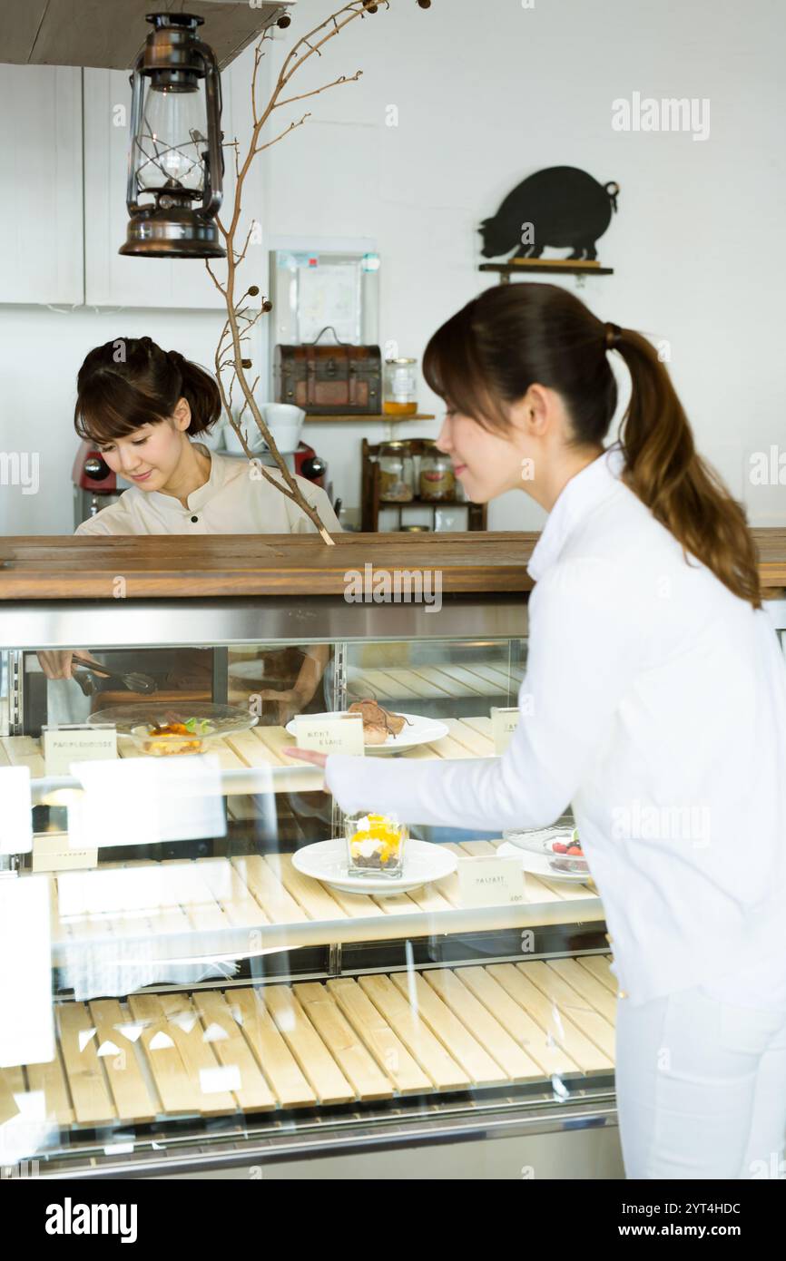 Clerk and customer at café counter Stock Photo - Alamy