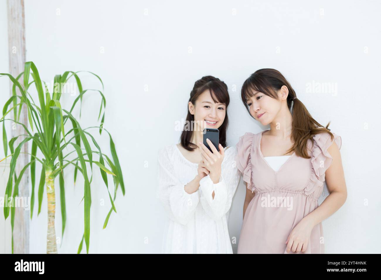 Two women using mobile phones Stock Photo - Alamy