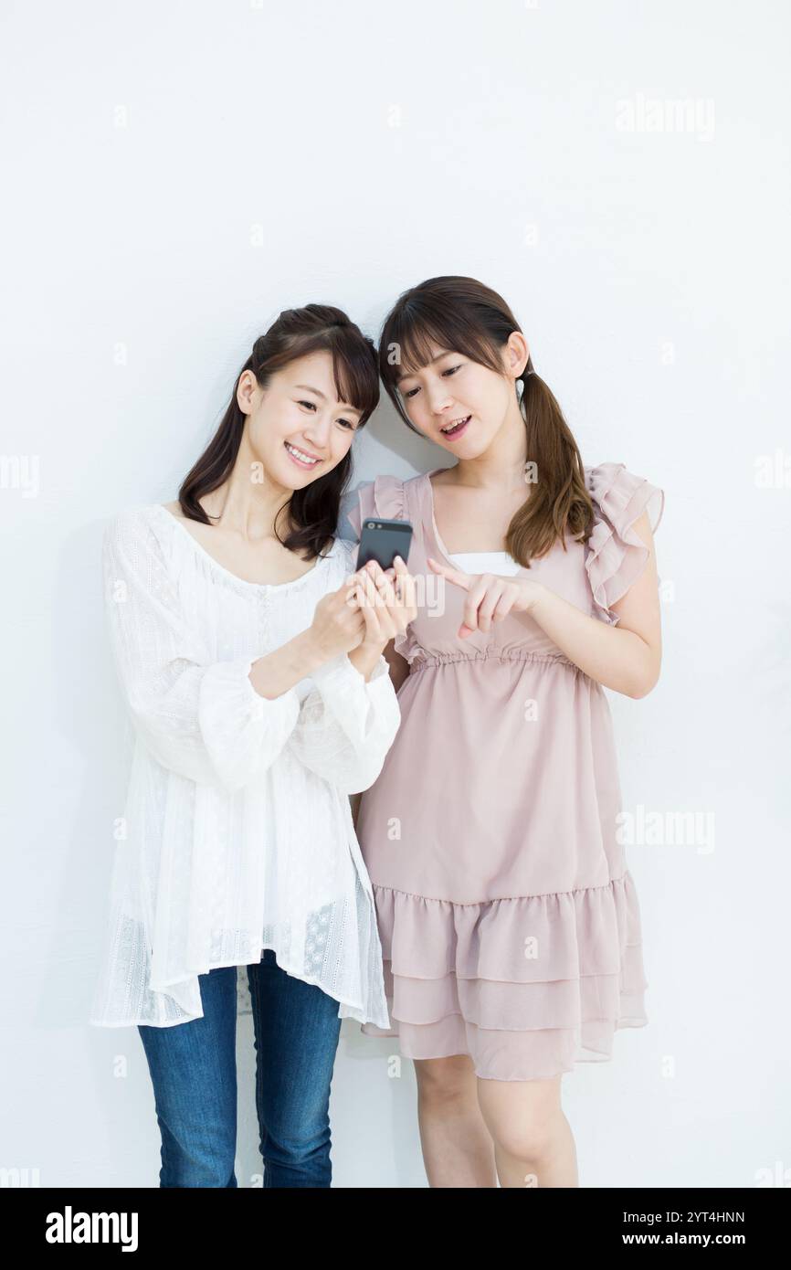 Two women using mobile phones Stock Photo - Alamy