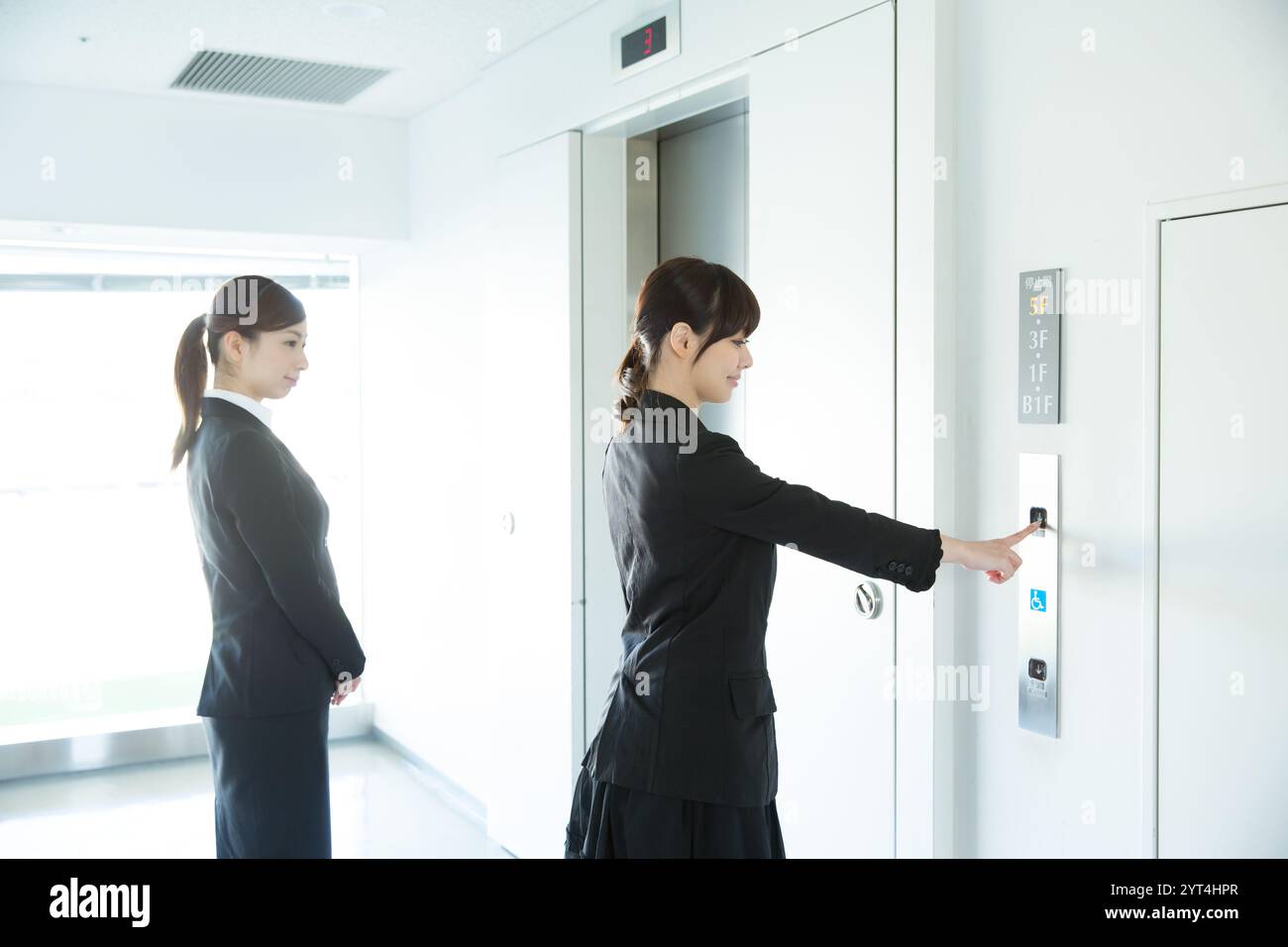 Businesswoman pushing elevator buttons Stock Photo - Alamy