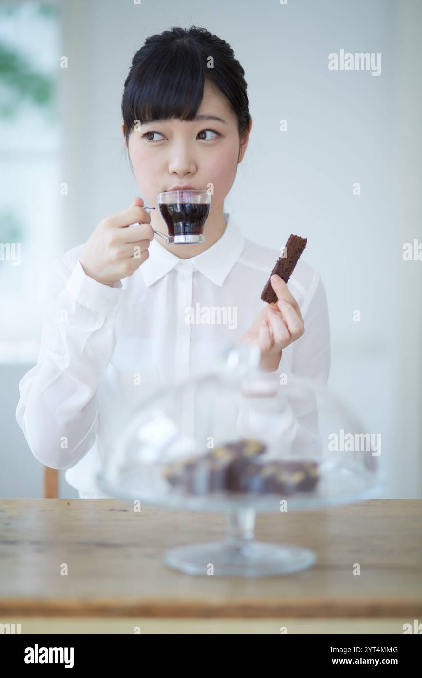 Young woman enjoying tea time Stock Photo - Alamy