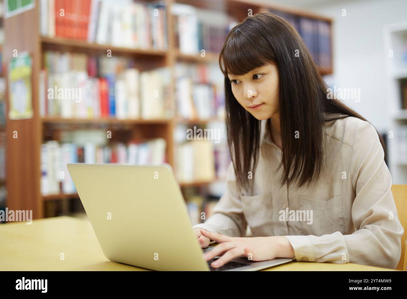 Female university students using computers in the library Stock Photo ...