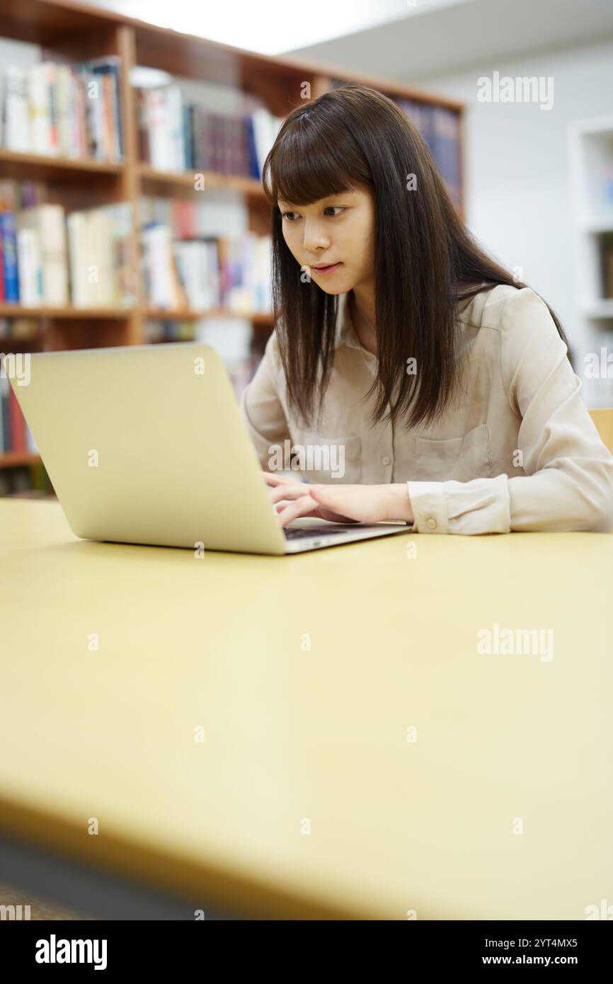Female university students using computers in the library Stock Photo ...