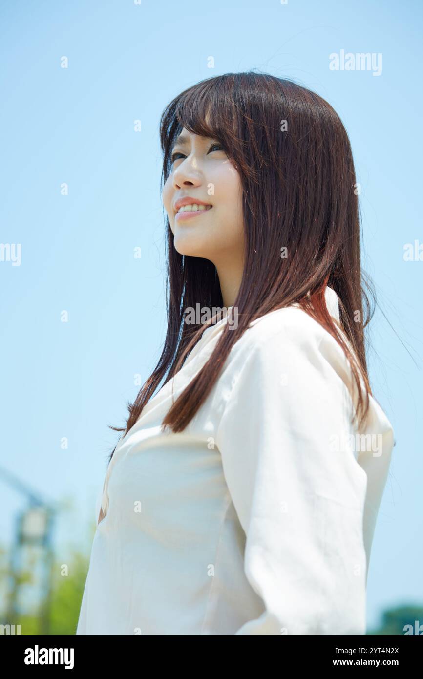 Blue sky and young woman Stock Photo - Alamy