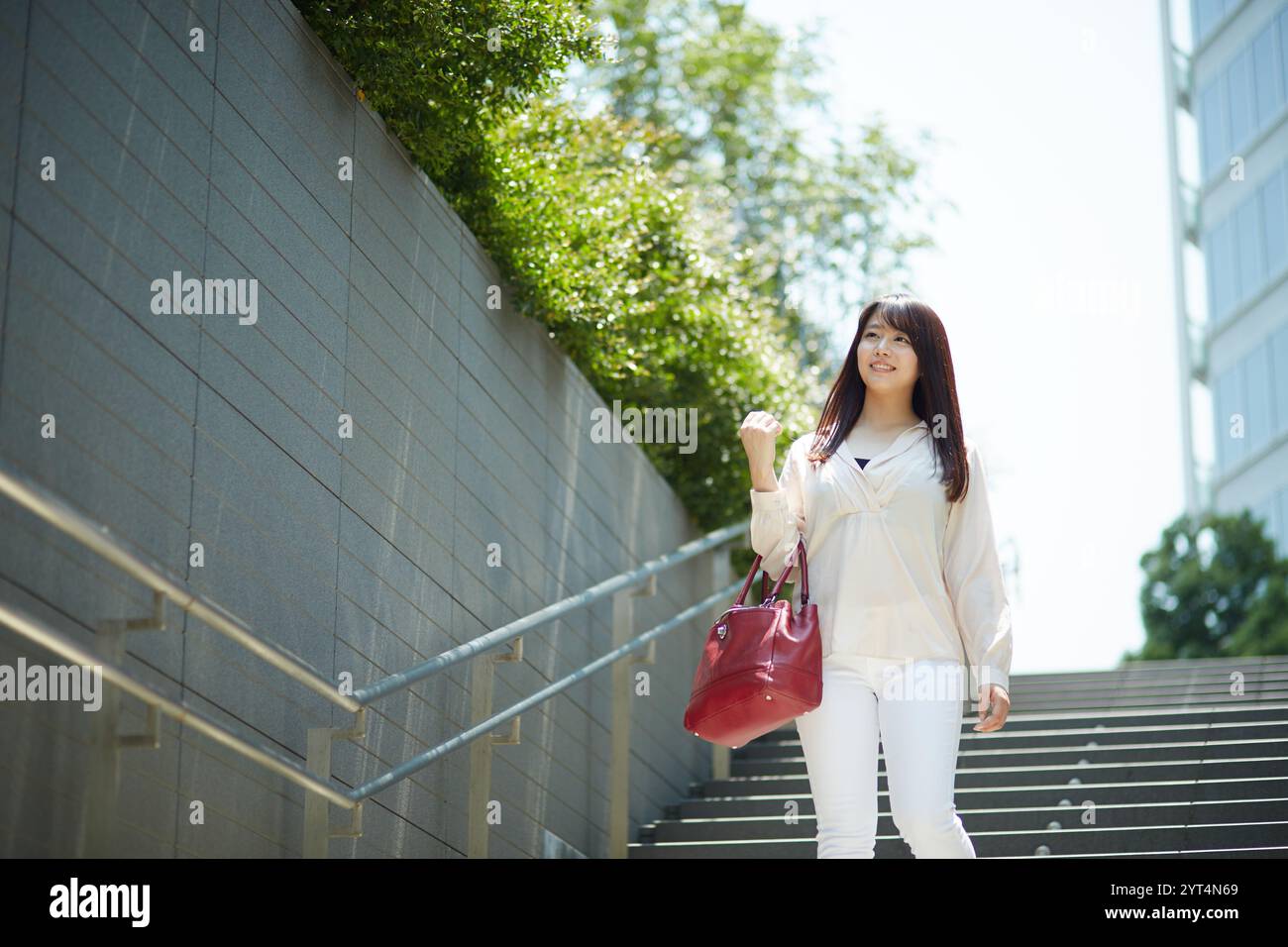 Young woman descending stairs Stock Photo - Alamy