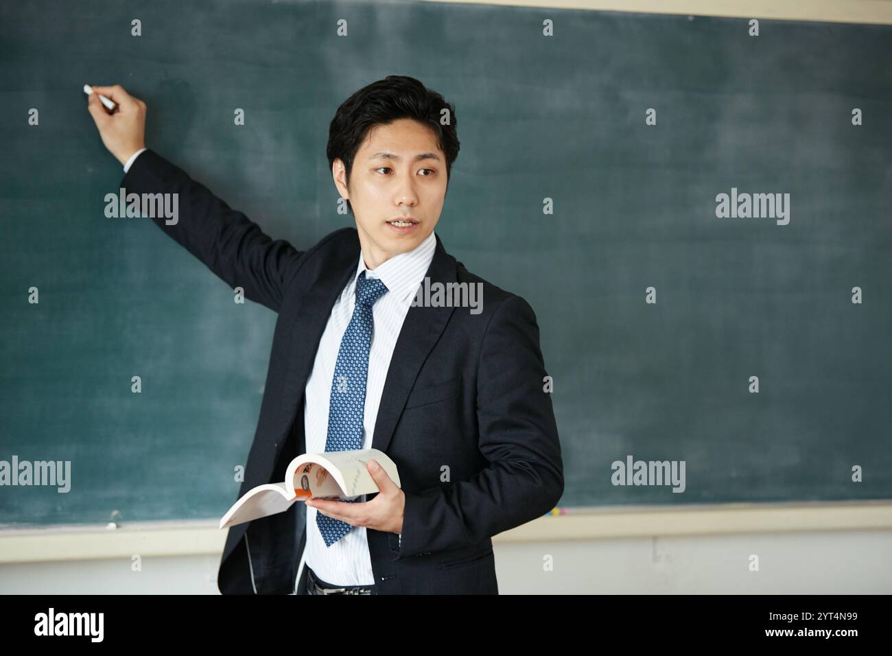 Male teacher explaining on the blackboard Stock Photo - Alamy