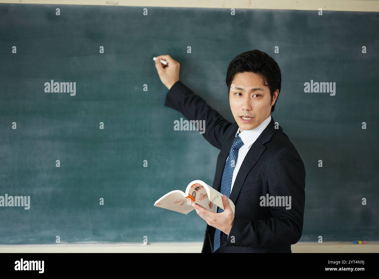Male teacher explaining on the blackboard Stock Photo - Alamy