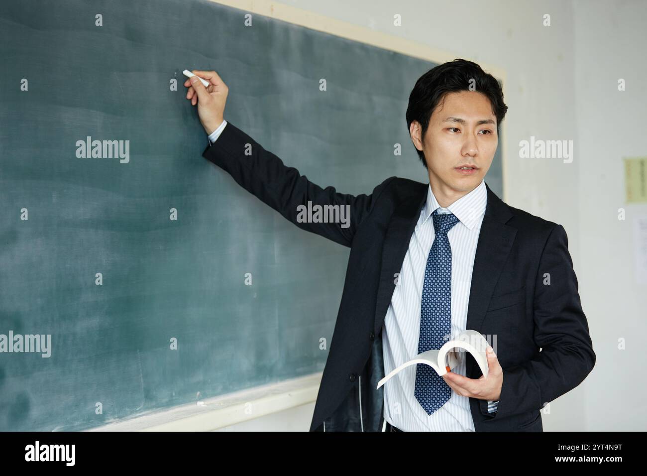 Male teacher explaining on the blackboard Stock Photo - Alamy