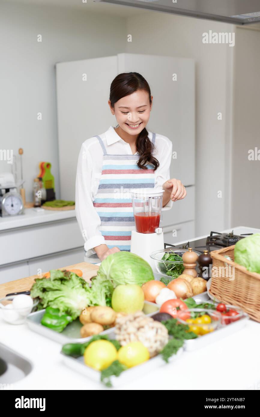 Two women making vegetable smoothies Stock Photo - Alamy