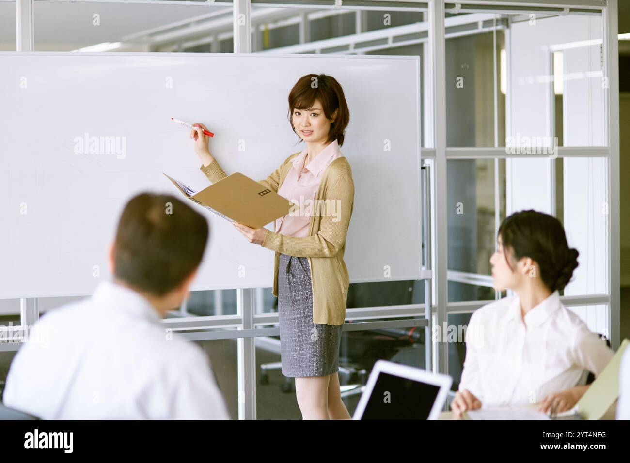 Woman explaining on whiteboard Stock Photo - Alamy