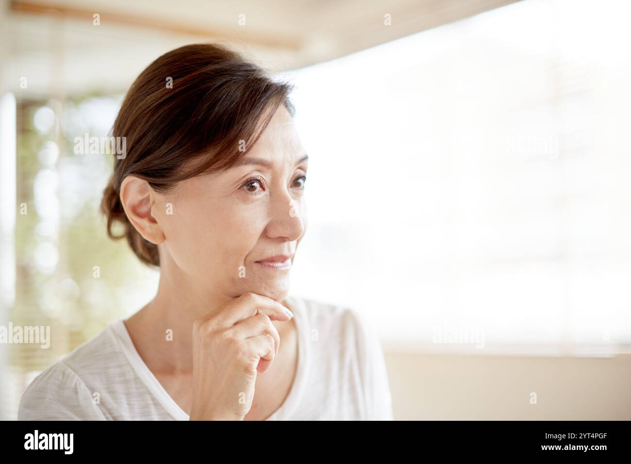 Woman resting her hand on her chin Stock Photo - Alamy