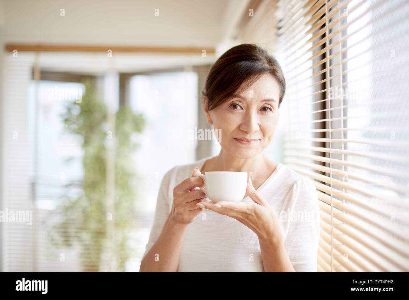Woman drinking coffee by the window Stock Photo - Alamy