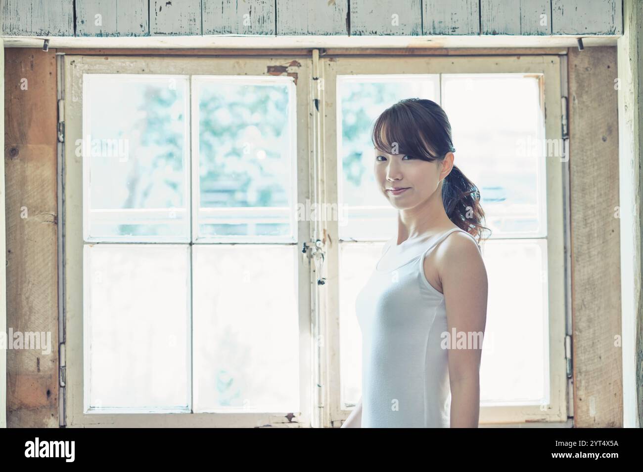 Woman relaxing by window Stock Photo - Alamy