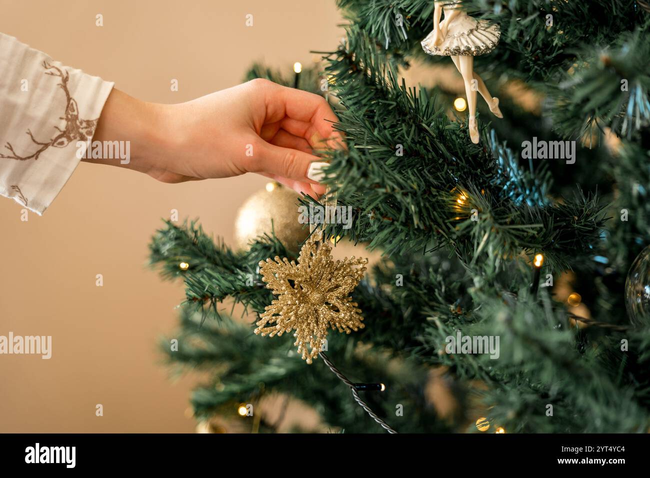 Adding Gold Snowflake Ornament to Christmas Tree Stock Photo - Alamy