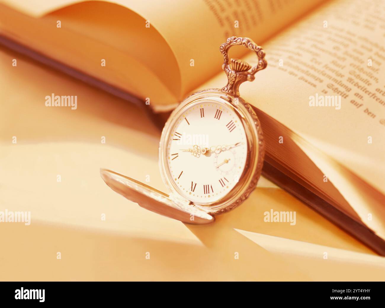 Pocket watch and book Stock Photo - Alamy
